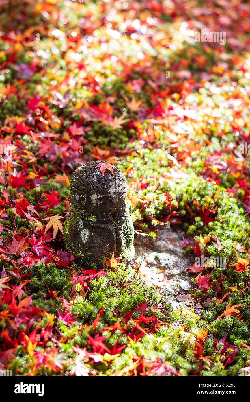 Japanese Jizo sculpture doll with falling Red Maple leaf in Japanese ...