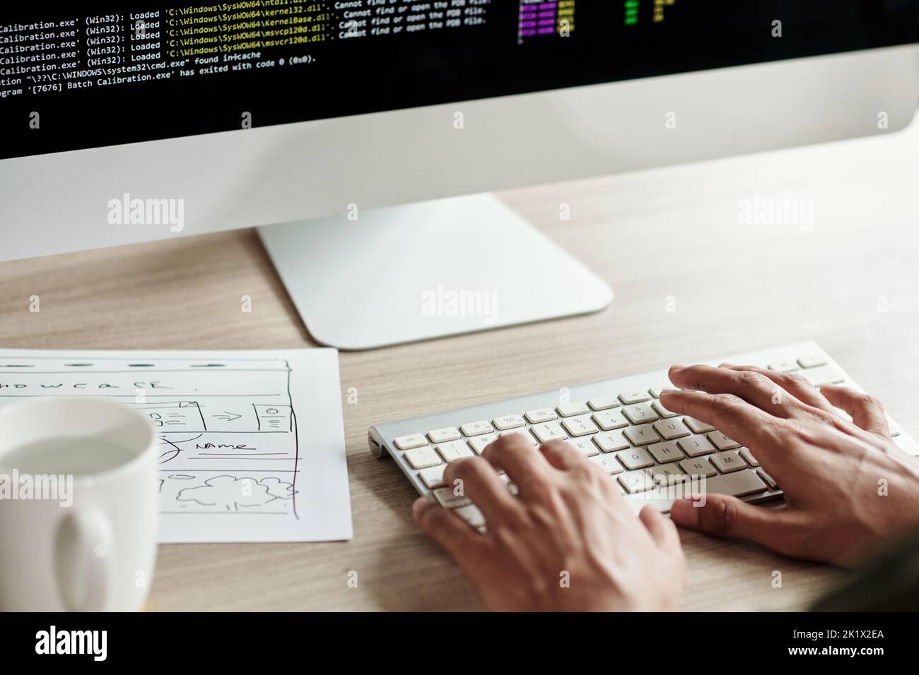 Closeup image of front end developer checking website hand-drawn website wireframe when coding ...