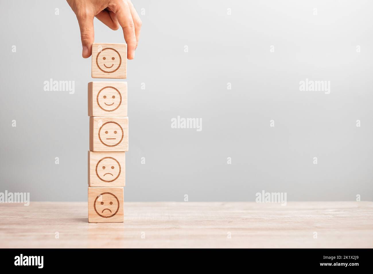 Man hand holding emotion face block. Customer choose Emoticon for user ...