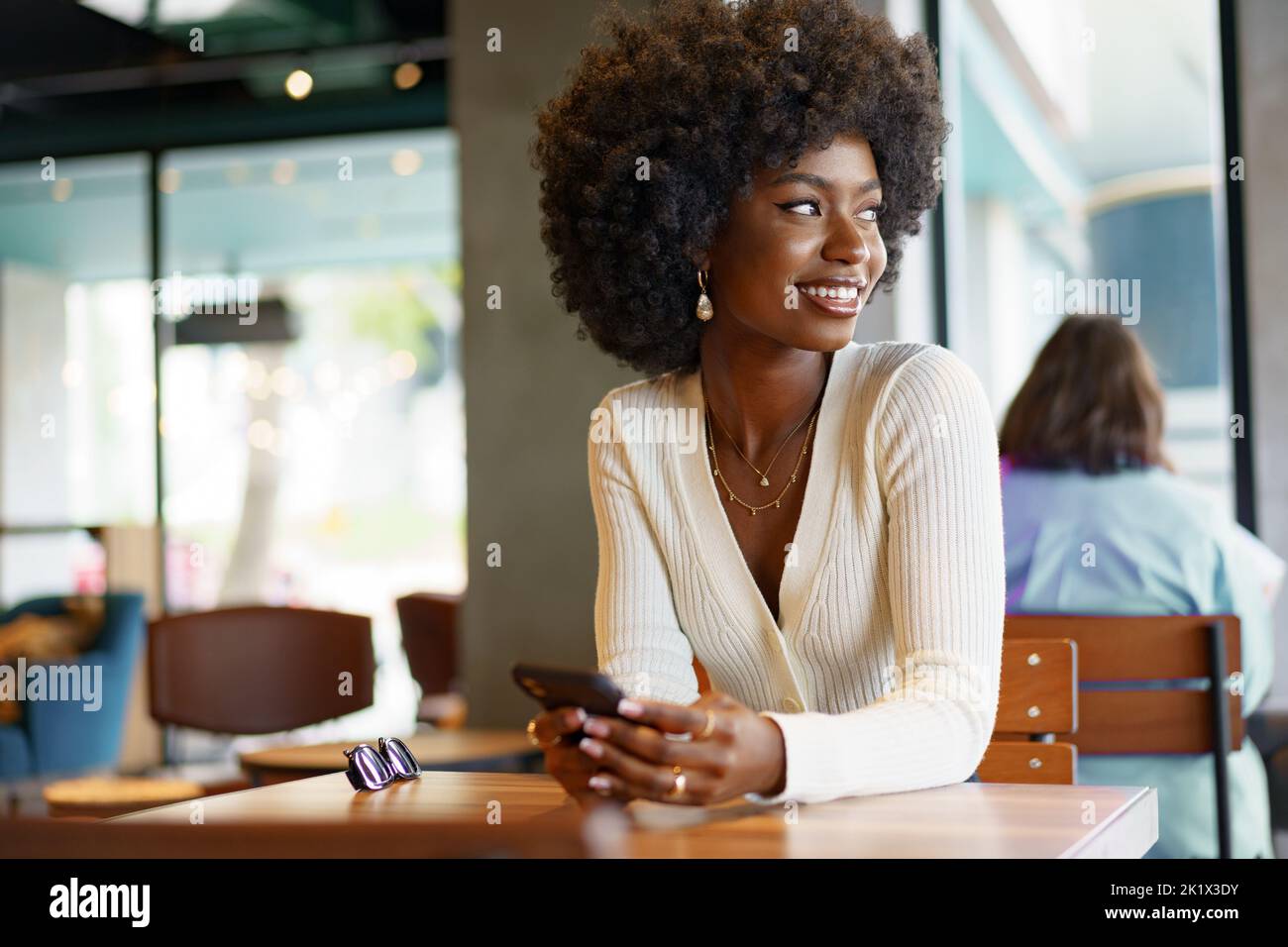 Young woman using mobile phone at coffee shop Stock Photo - Alamy