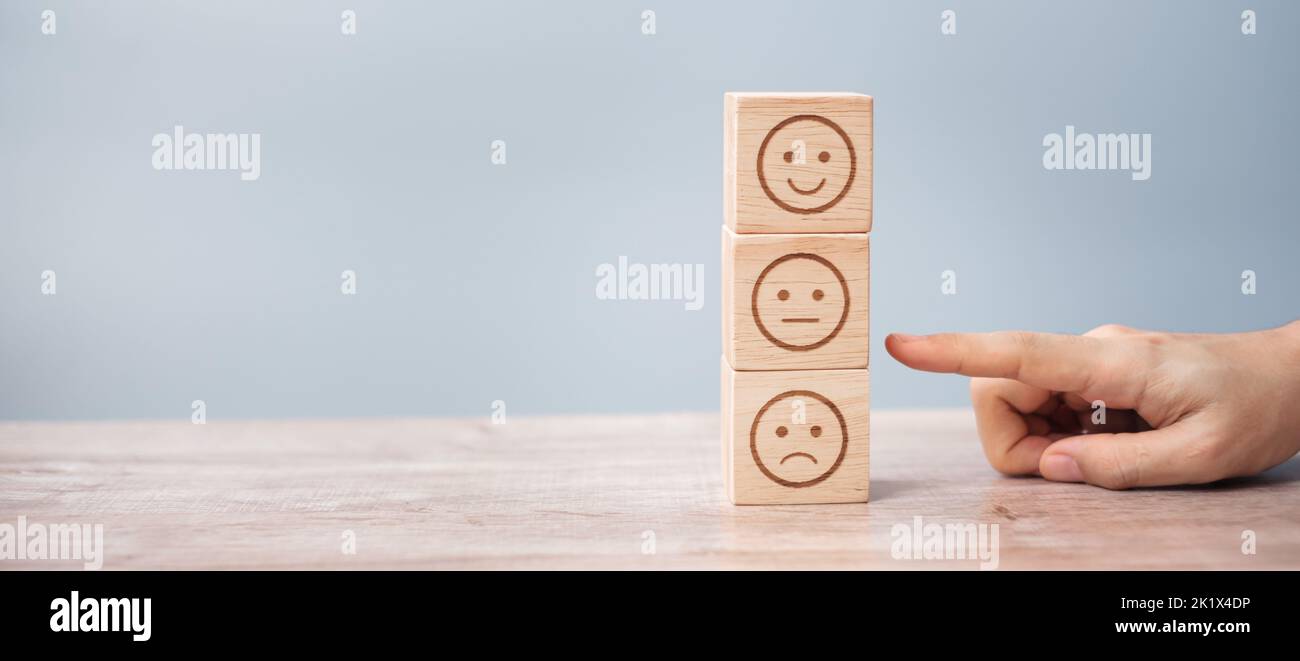 Man hand holding emotion face block. Customer choose Emoticon for user ...