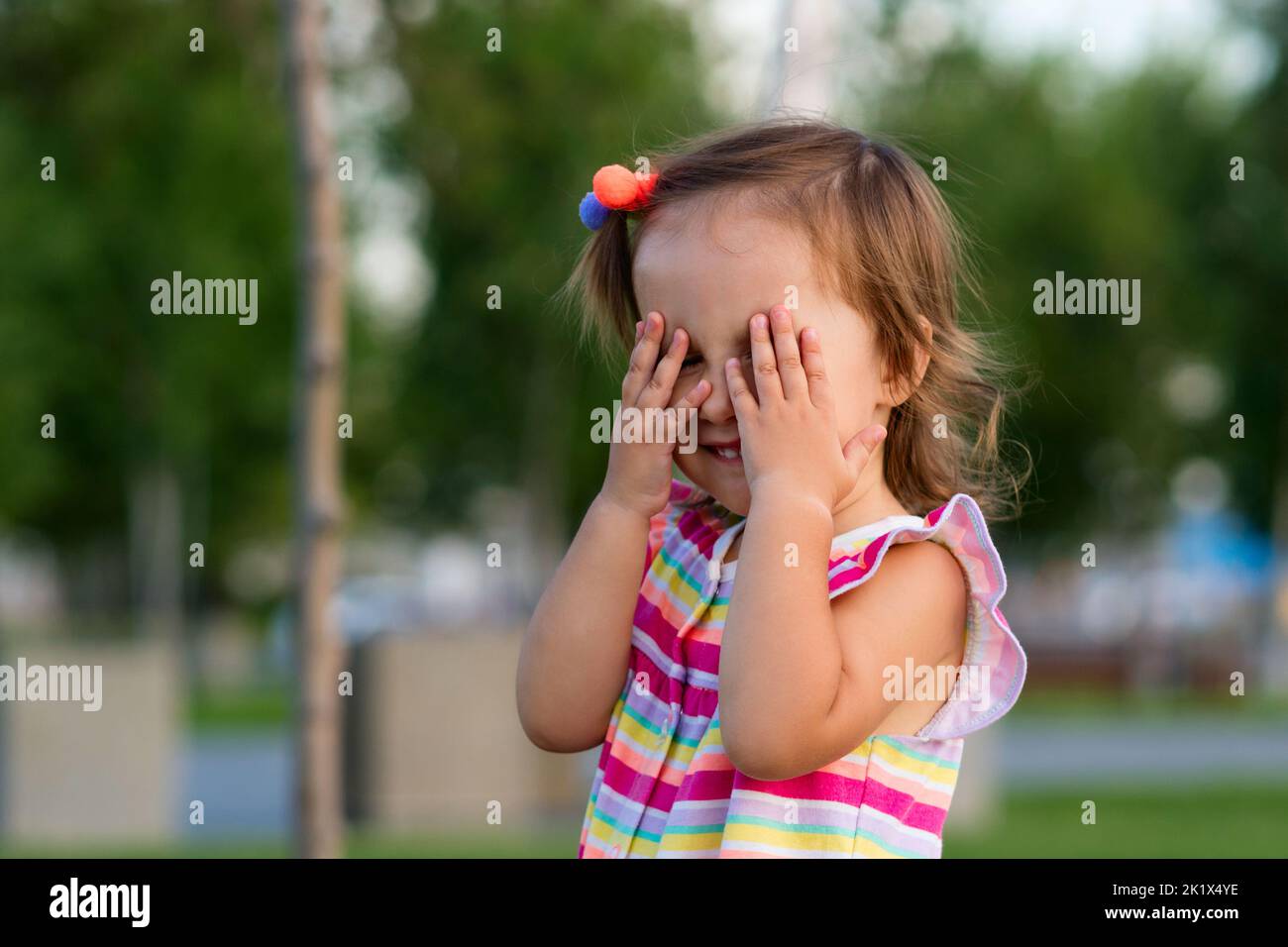 Toddler baby girl wears bright striped summer bodysuit in playing game ...