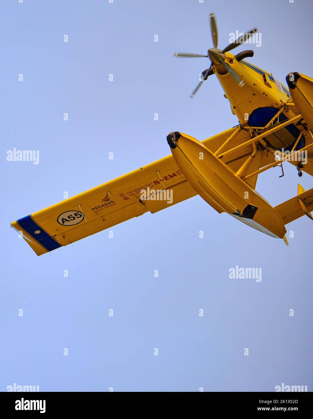A yellow hydroplane flying in clear blue skies Stock Photo - Alamy