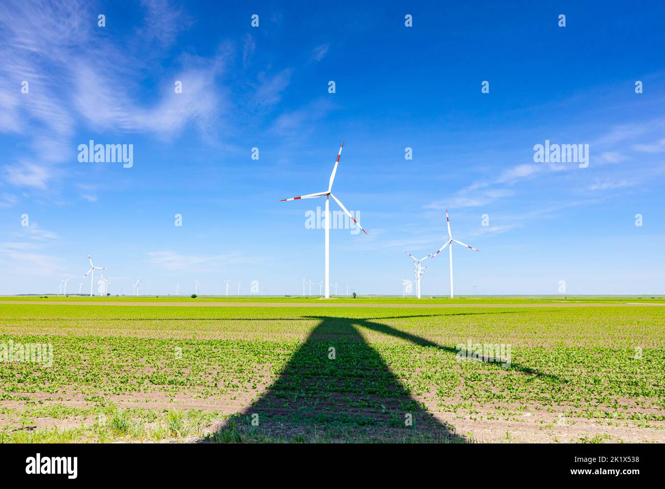 Long shadow under wind generator, turbines, with rotating blades ...