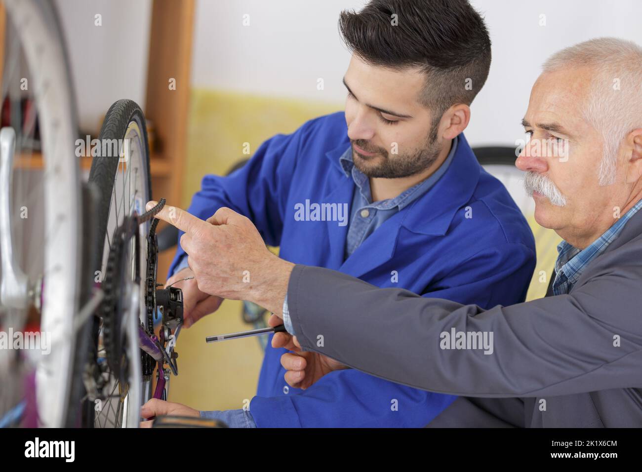 Mechanic checking chain tautness on bicycle Stock Photo - Alamy