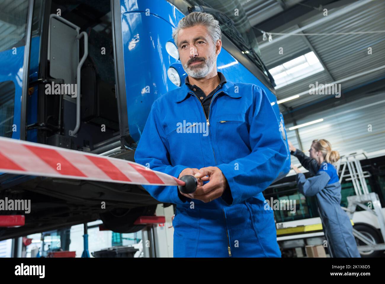 mechanic putting protective tape around work area Stock Photo - Alamy