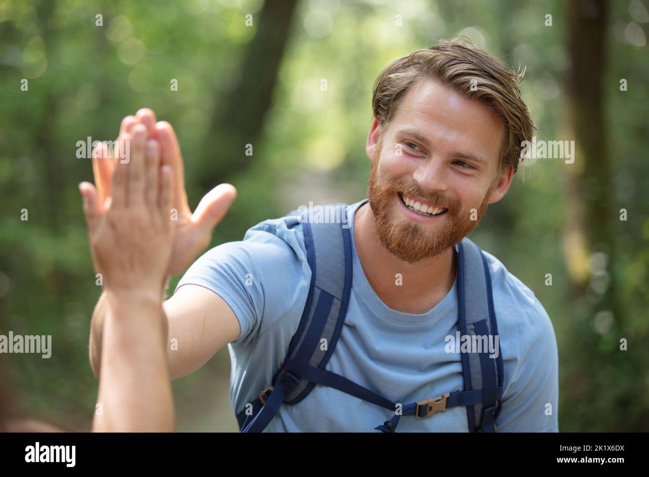 hiker is walking in the woods giving high five Stock Photo - Alamy