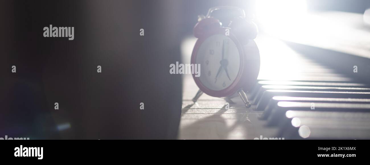 Alarm clock on piano background. Music lesson Stock Photo - Alamy