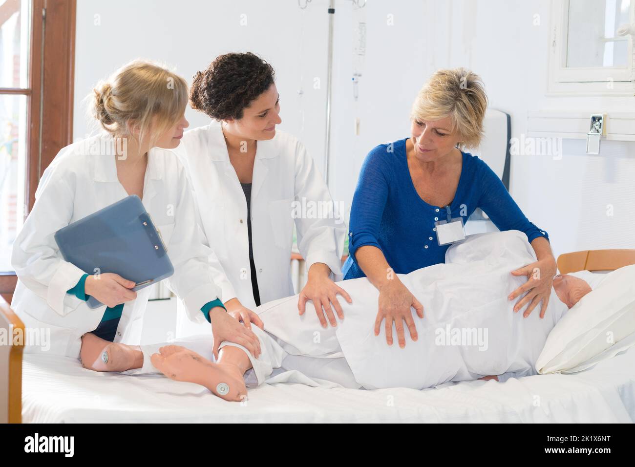 nurses practicing how to roll a patient with dummy Stock Photo - Alamy
