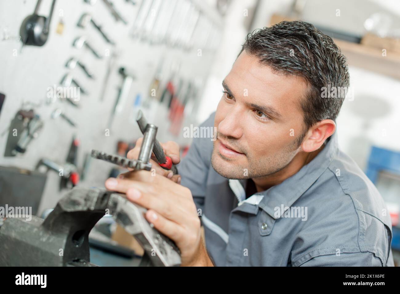 Mechanic filing spindle of cog Stock Photo - Alamy