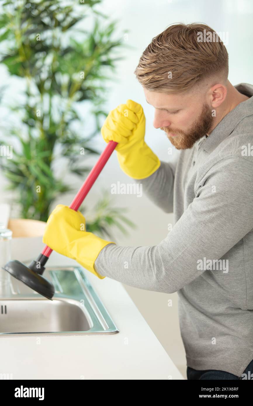 cleaning clogged pipes in the kitchen sink with a plunger Stock Photo ...