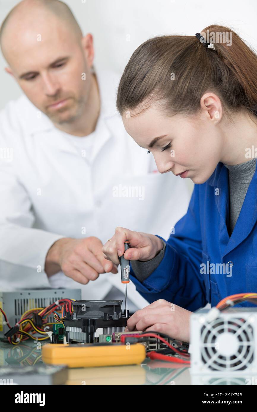 female engineering student making connections for electronics ...