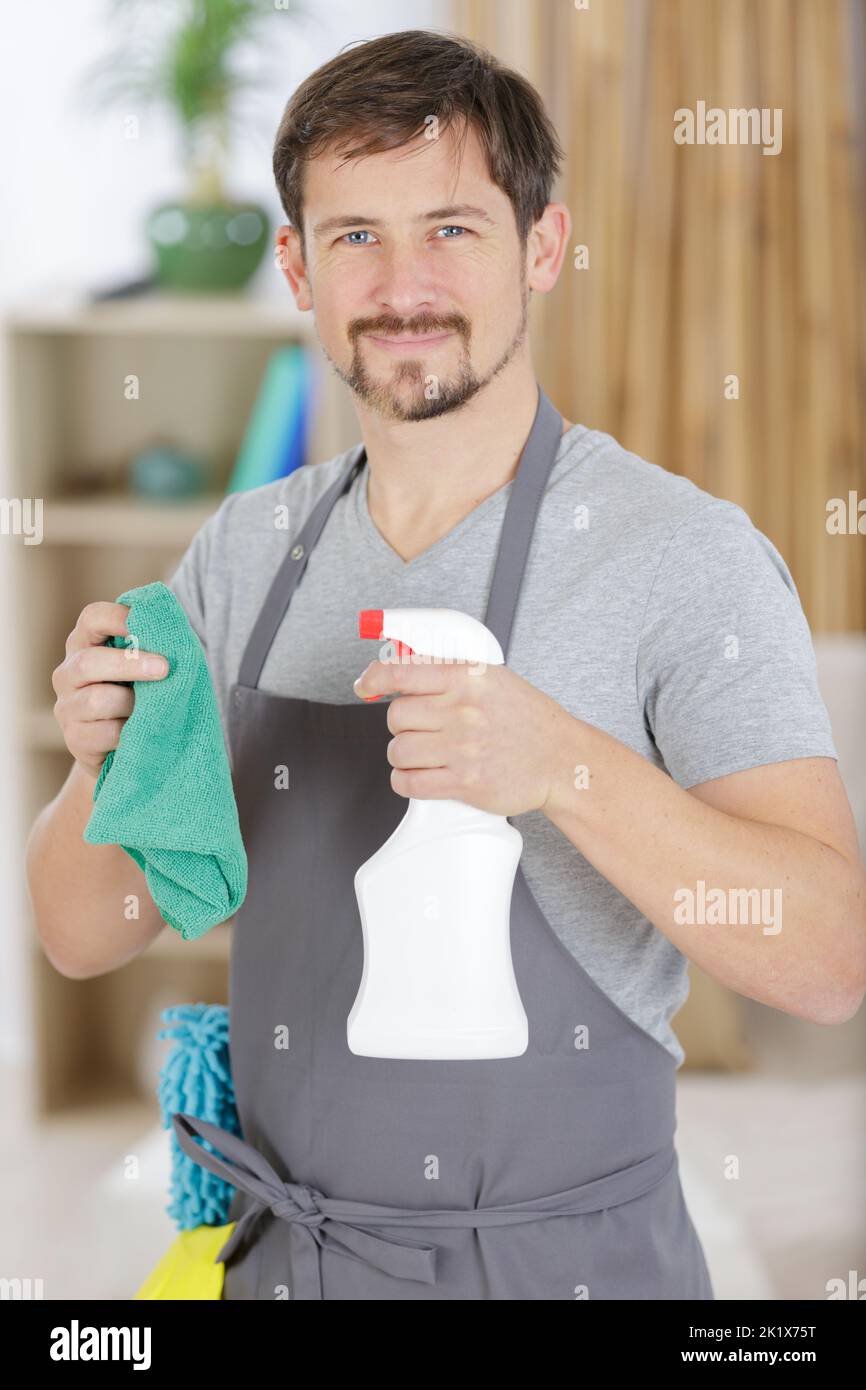 man with apron holding a spray Stock Photo - Alamy