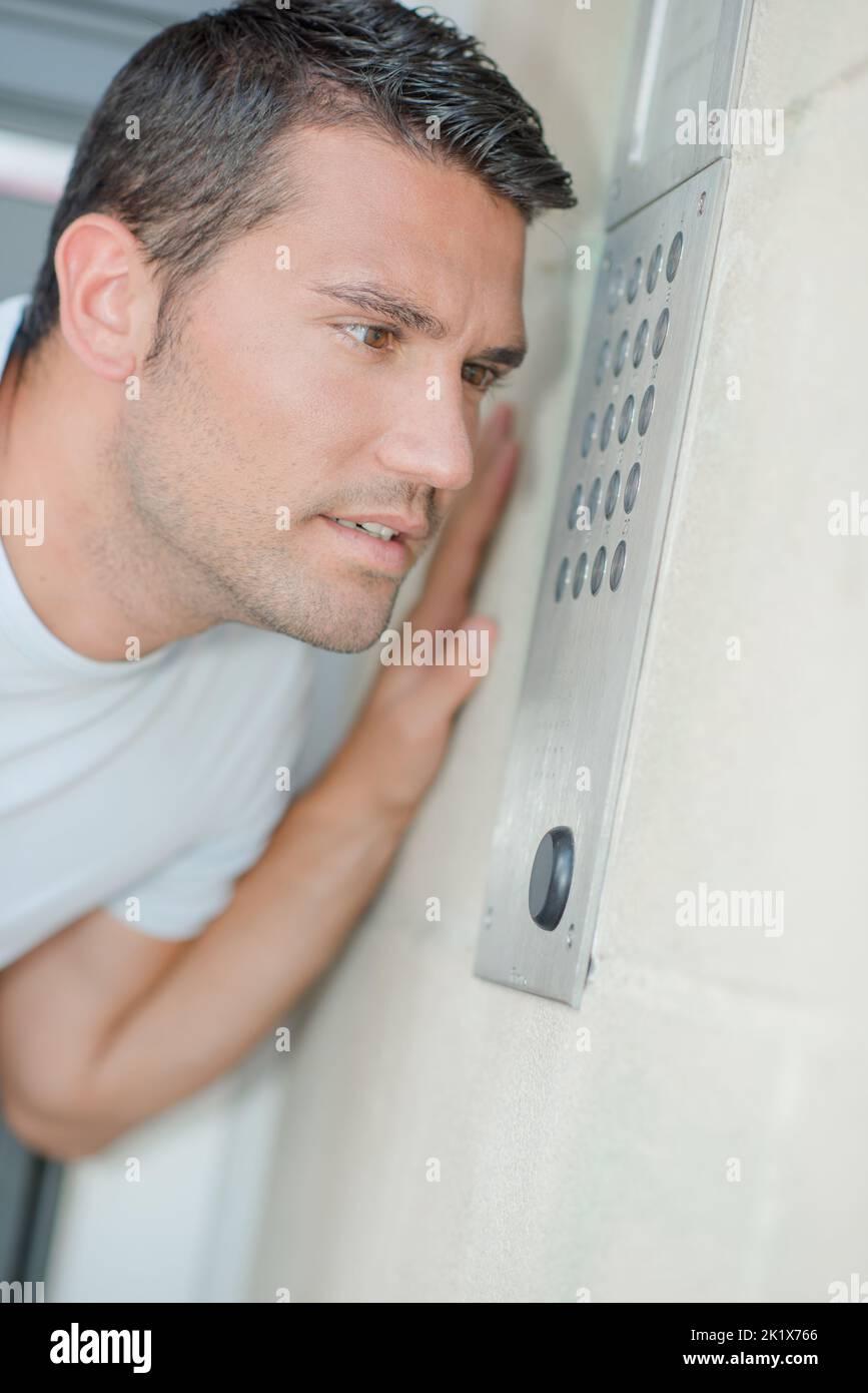 Man speaking into an intercom system Stock Photo - Alamy