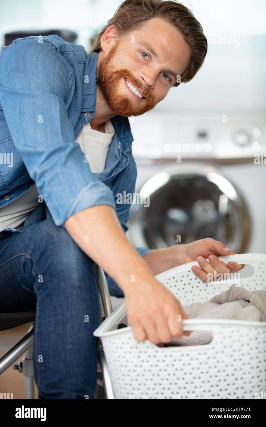 midsection of young man with clothes basket in laundry Stock Photo - Alamy