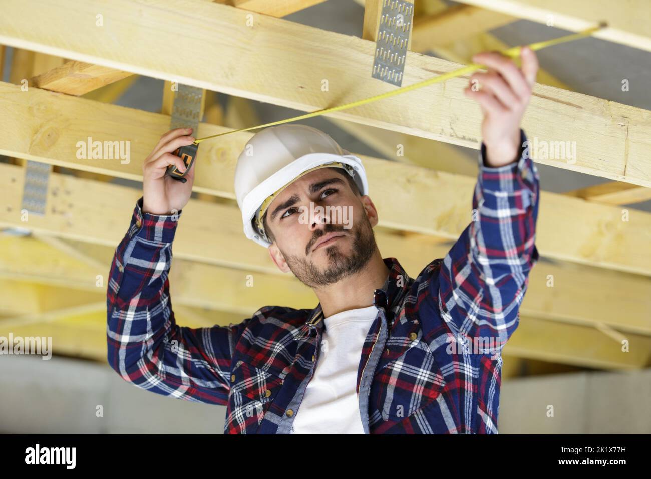 male builder is measuring the ceiling Stock Photo - Alamy