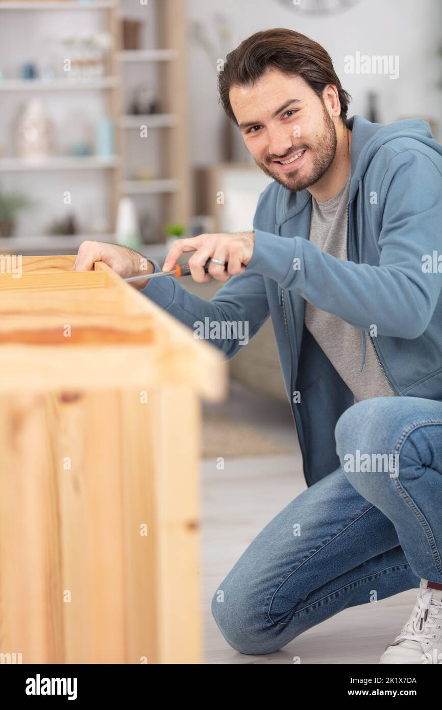 frustrated man putting together self assembly furniture Stock Photo - Alamy