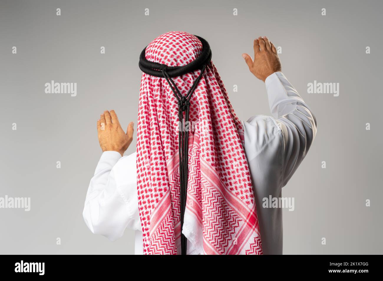 Back view of young Arab man standing on gray background Stock Photo - Alamy