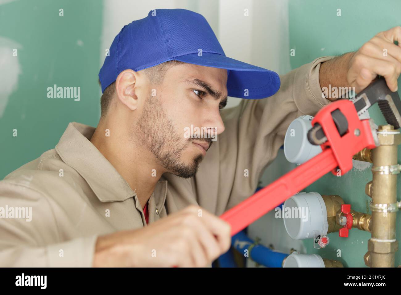 male plumber fixing water meter with adjustable wrench Stock Photo - Alamy