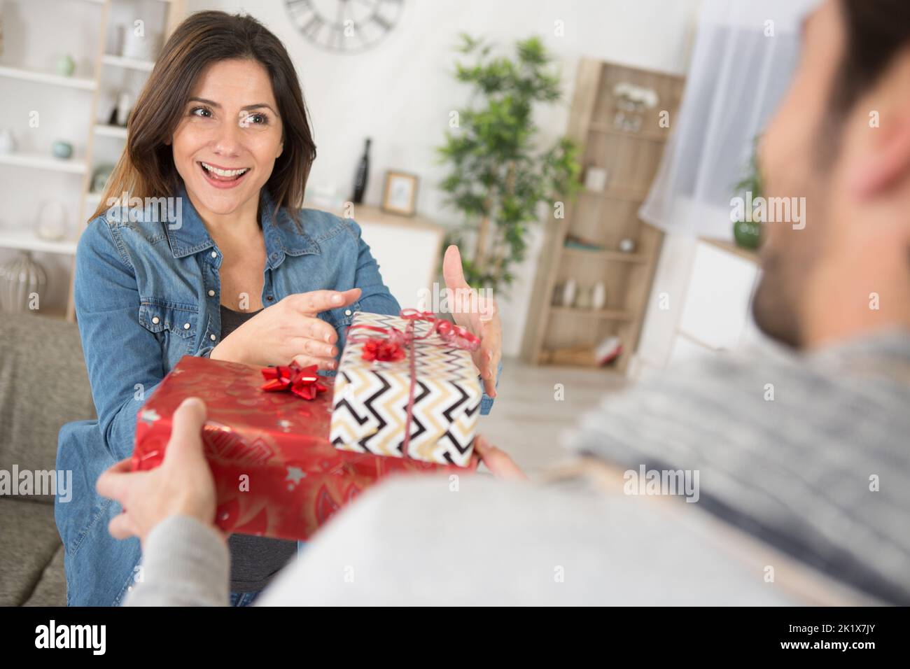 excited woman giving christmas gifts Stock Photo - Alamy