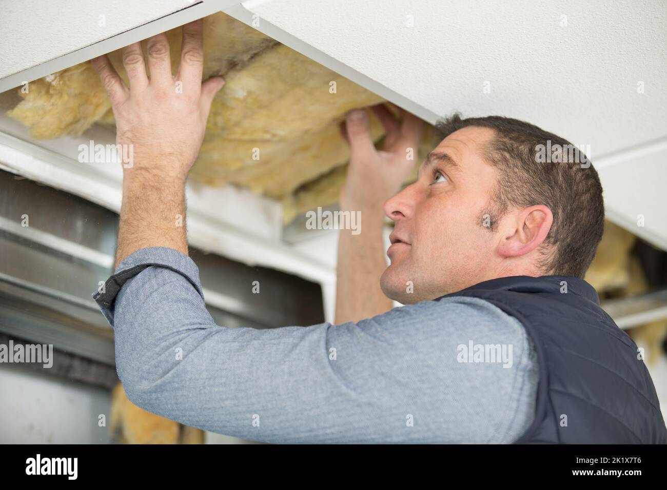 caucasian man fixes ceiling skirting Stock Photo - Alamy