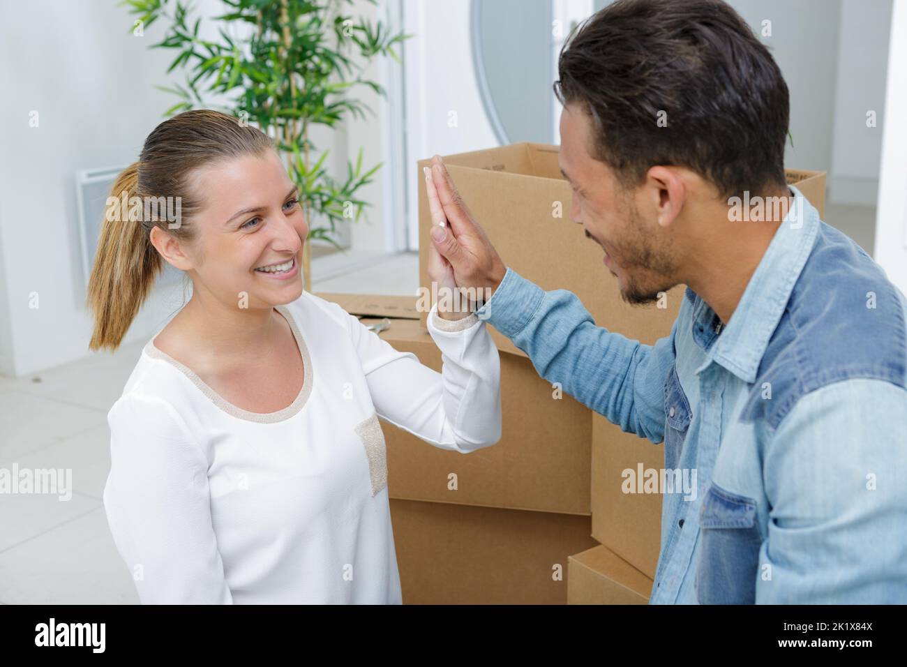 happy and young couple giving high five Stock Photo - Alamy