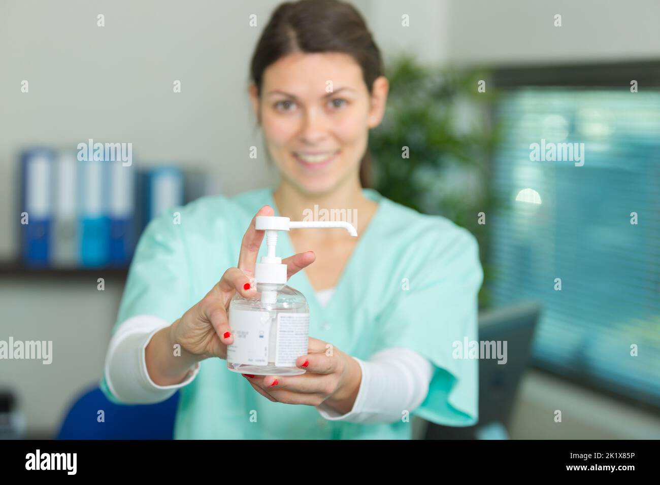 female nurse holding forward a pump dispensing hand sanitiser Stock ...