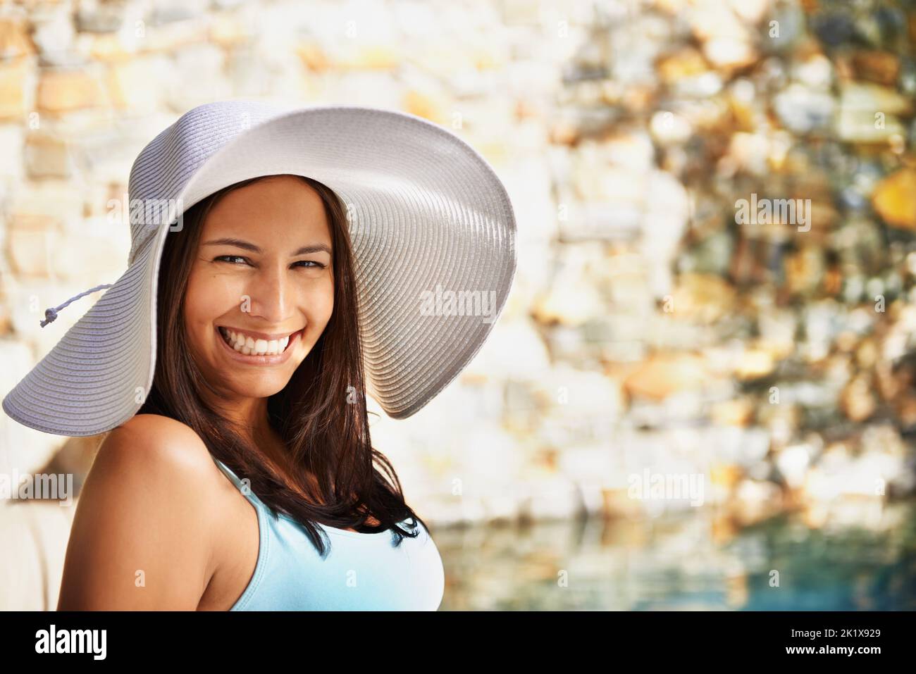 Keeping safe from the sun. An attractive woman wearing a sun hat while ...