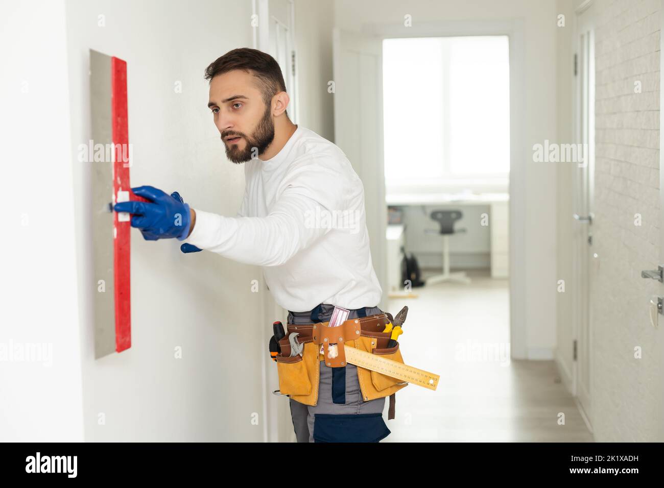 man plasterer construction worker at work, takes plaster from bucket ...