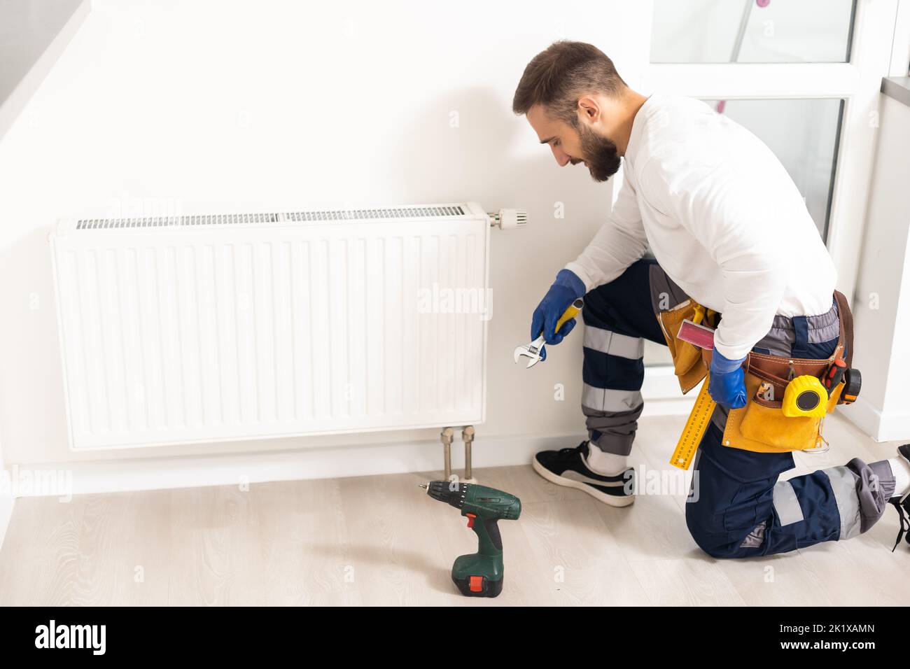 Repair heating radiator close-up. man repairing radiator with wrench ...