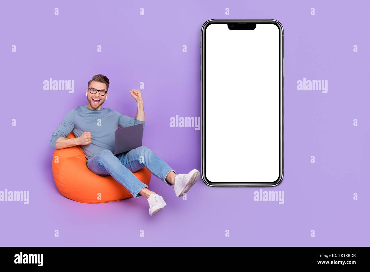 Photo of cute lucky guy dressed grey shirt sitting bean bag typing ...