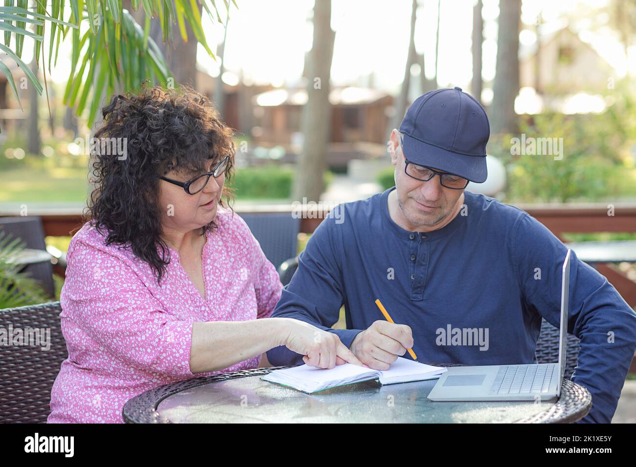 Concentrated man in cap and woman in glasses talking to each other ...