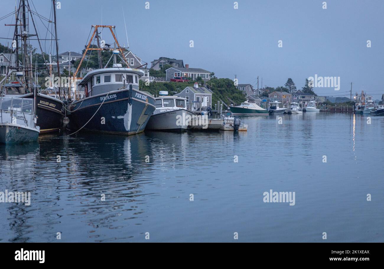 A commercial fishing and lobster boat at dusk in a New England harbor ...