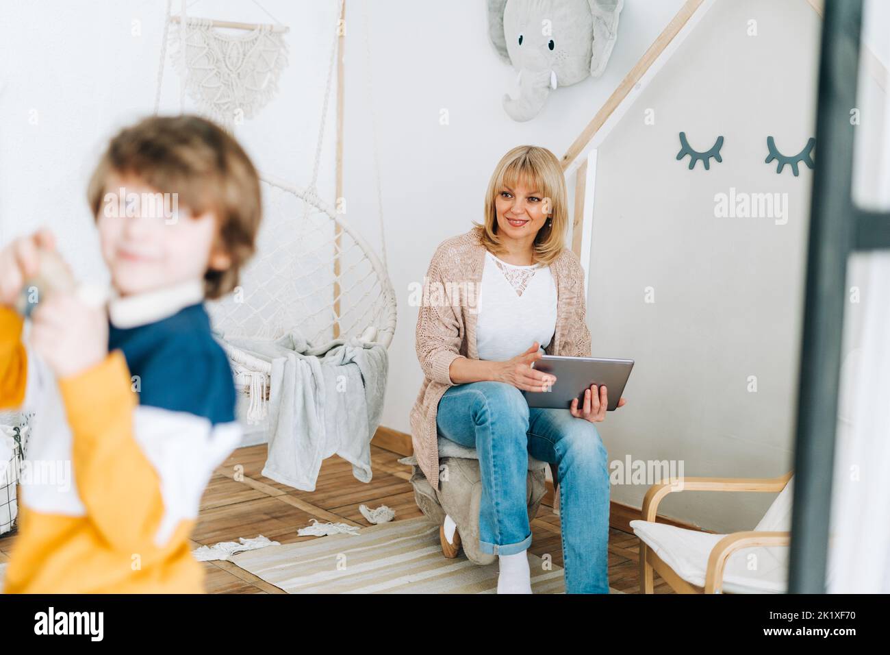 Caucasian school boy kid child playing with his mother mom while she ...