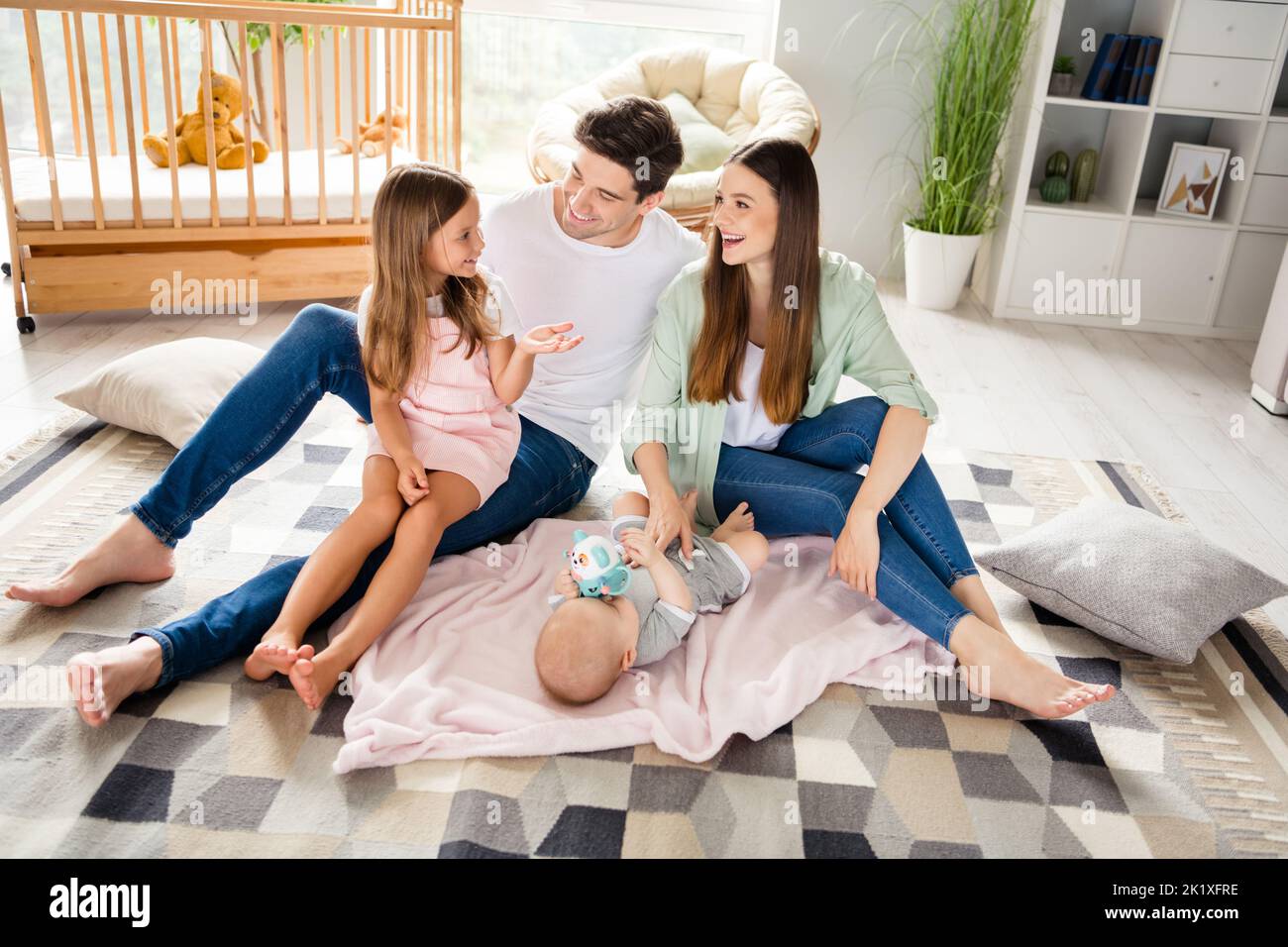 Full size portrait of full peaceful friendly family sitting carpet ...