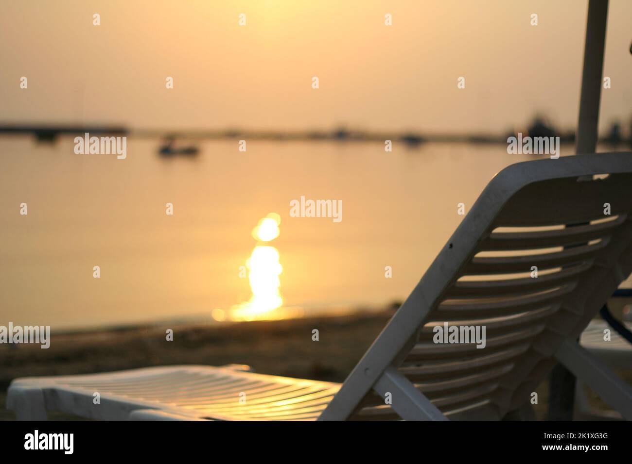 A deck chair in background of sea during sunset Stock Photo - Alamy