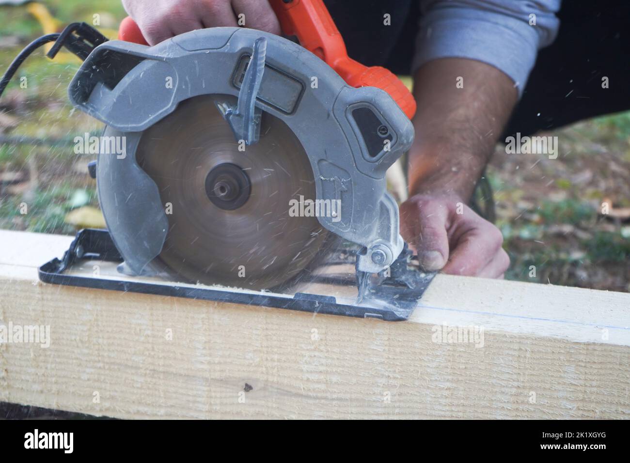 Close-up of a carpenter using a circular saw to cut a large board of ...
