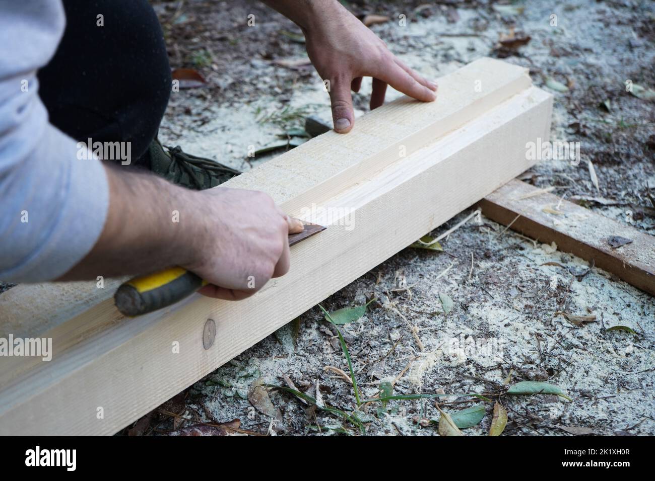 Closeup of a carpenter hands working with a chisel and carving tools on ...