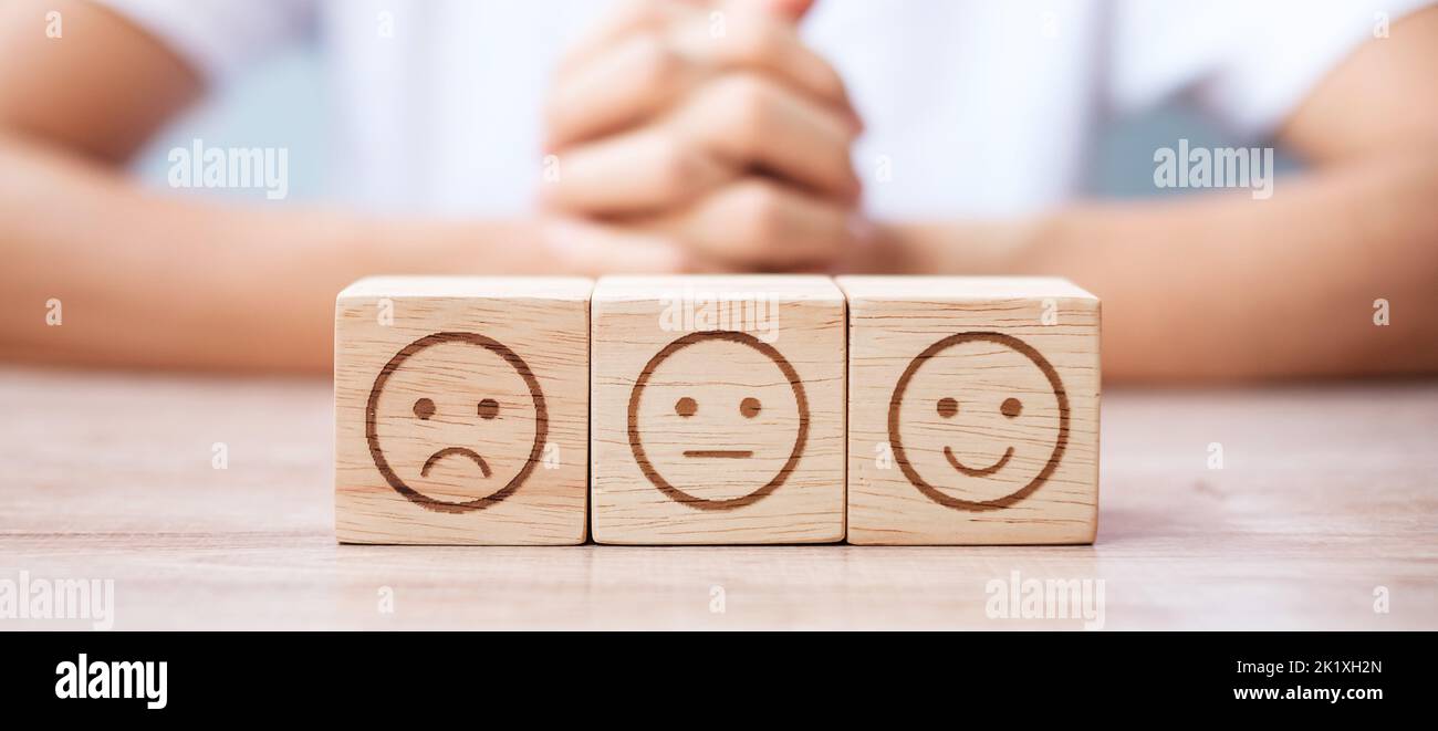 Man hand holding emotion face block. Customer choose Emoticon for user ...