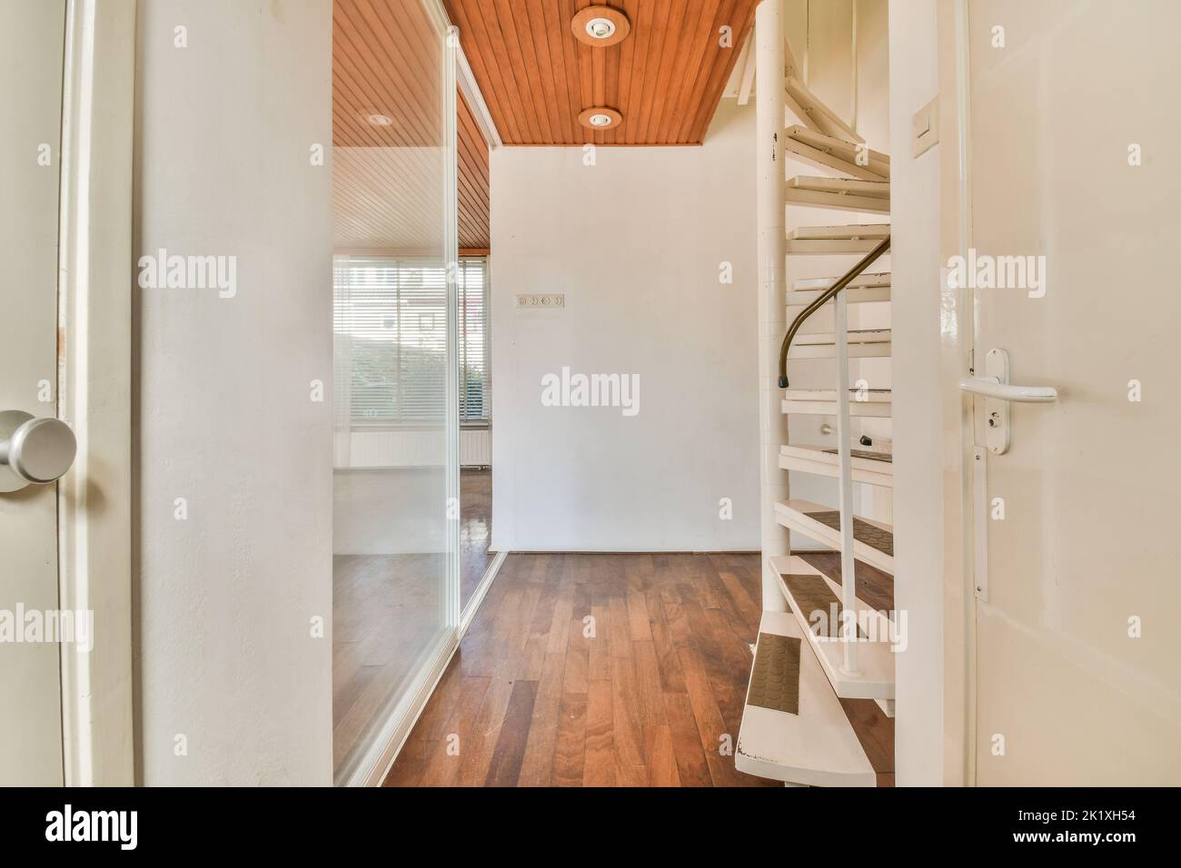 White spiral stairway connecting levels of contemporary house with ...