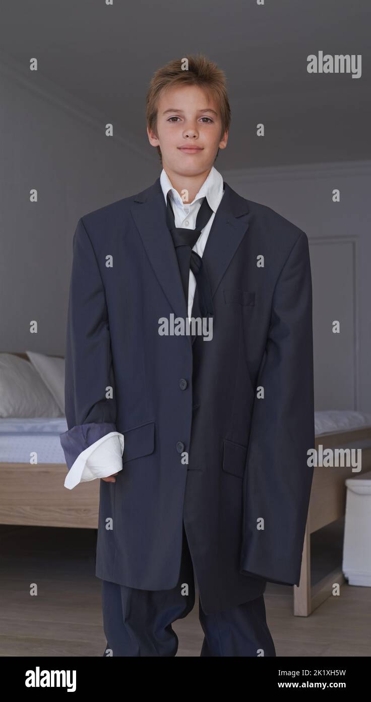 Growing up like dad. a young boy wearing his fathers suit and ...