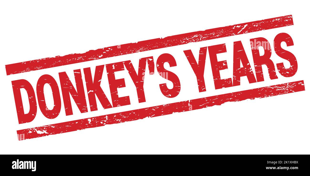 DONKEY'S YEARS text written on red rectangle stamp sign Stock Photo - Alamy