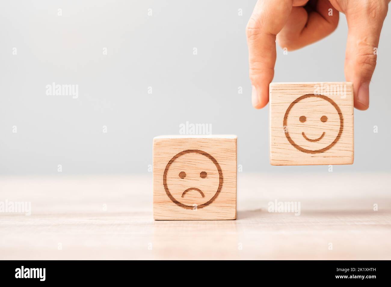 Man hand holding emotion face block. Customer choose Emoticon for user ...