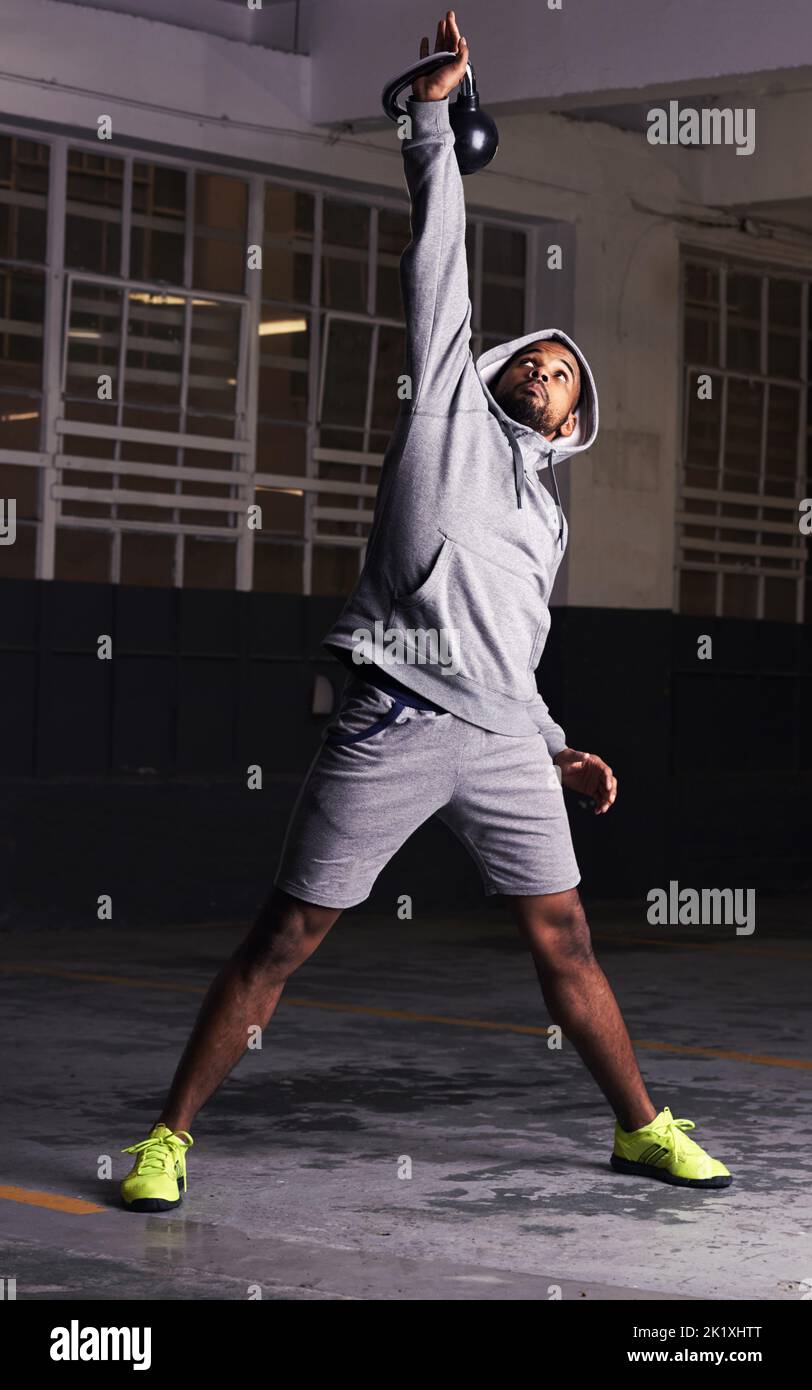 Getting stronger every day. a young man training with kettle bell ...