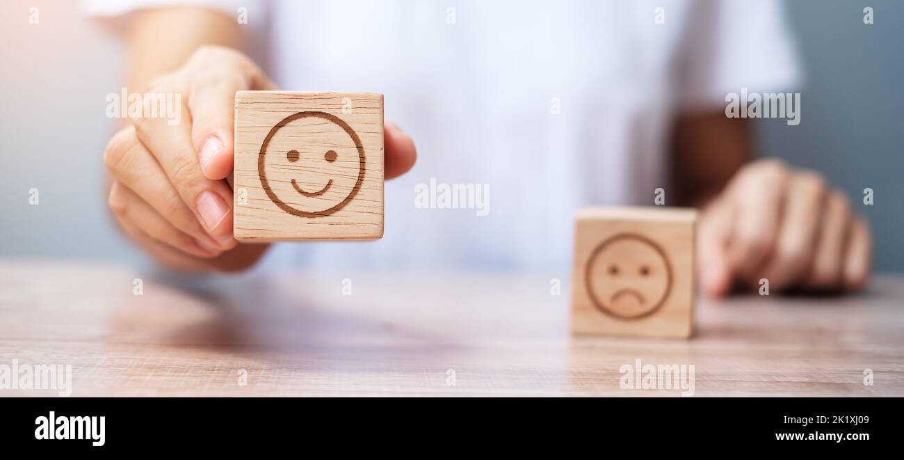 Man hand holding emotion face block. Customer choose Emoticon for user ...
