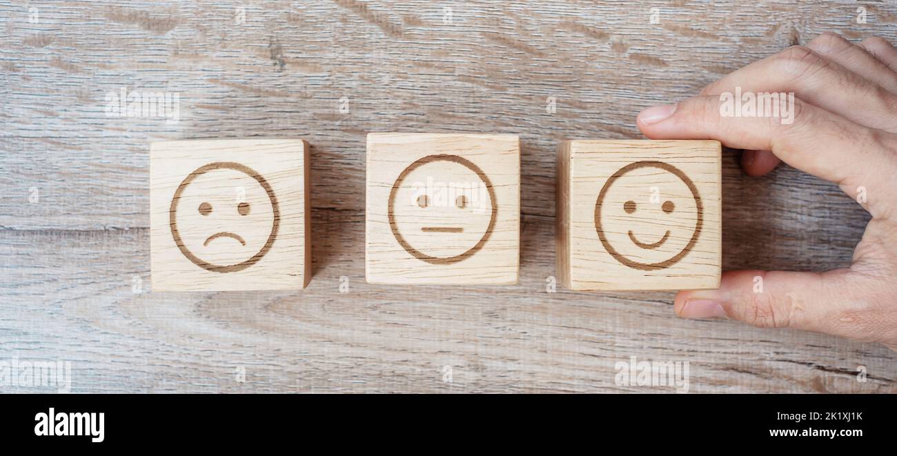 Man hand holding emotion face block. Customer choose Emoticon for user ...