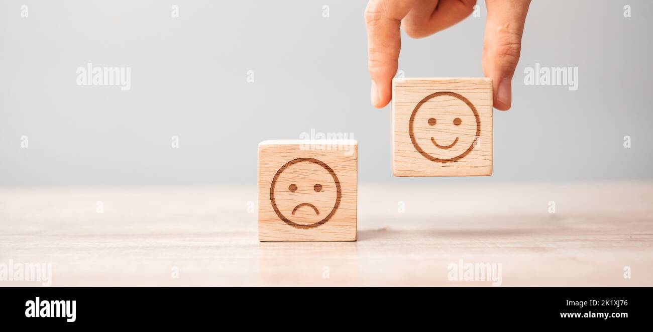 Man hand holding emotion face block. Customer choose Emoticon for user ...