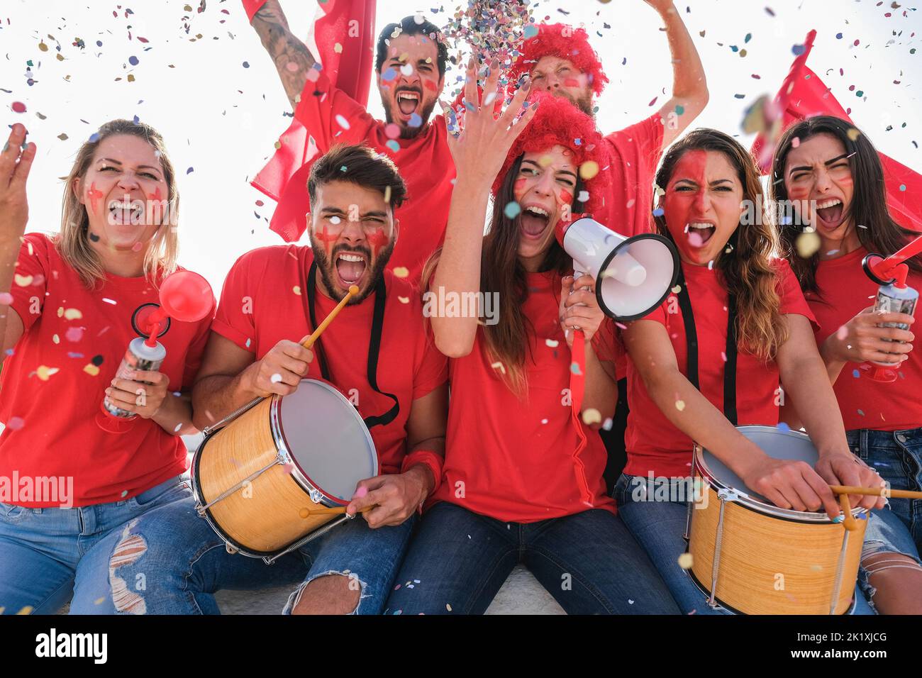 Red sport fans screaming while supporting their team out of the stadium ...