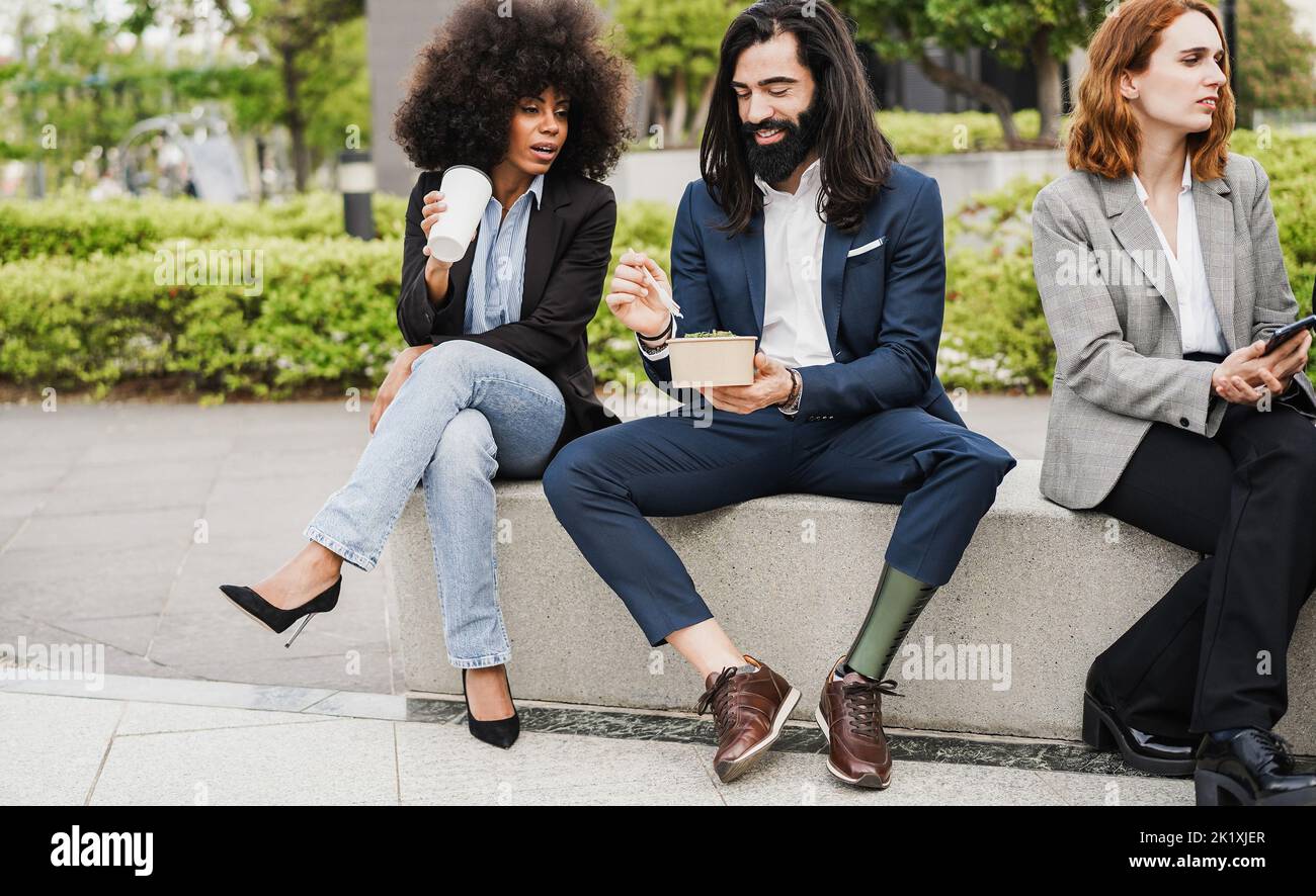 Diverse business people doing lunch break outdoor from office building ...
