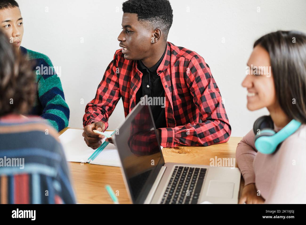 Multiracial students using laptop computers while studying together at ...